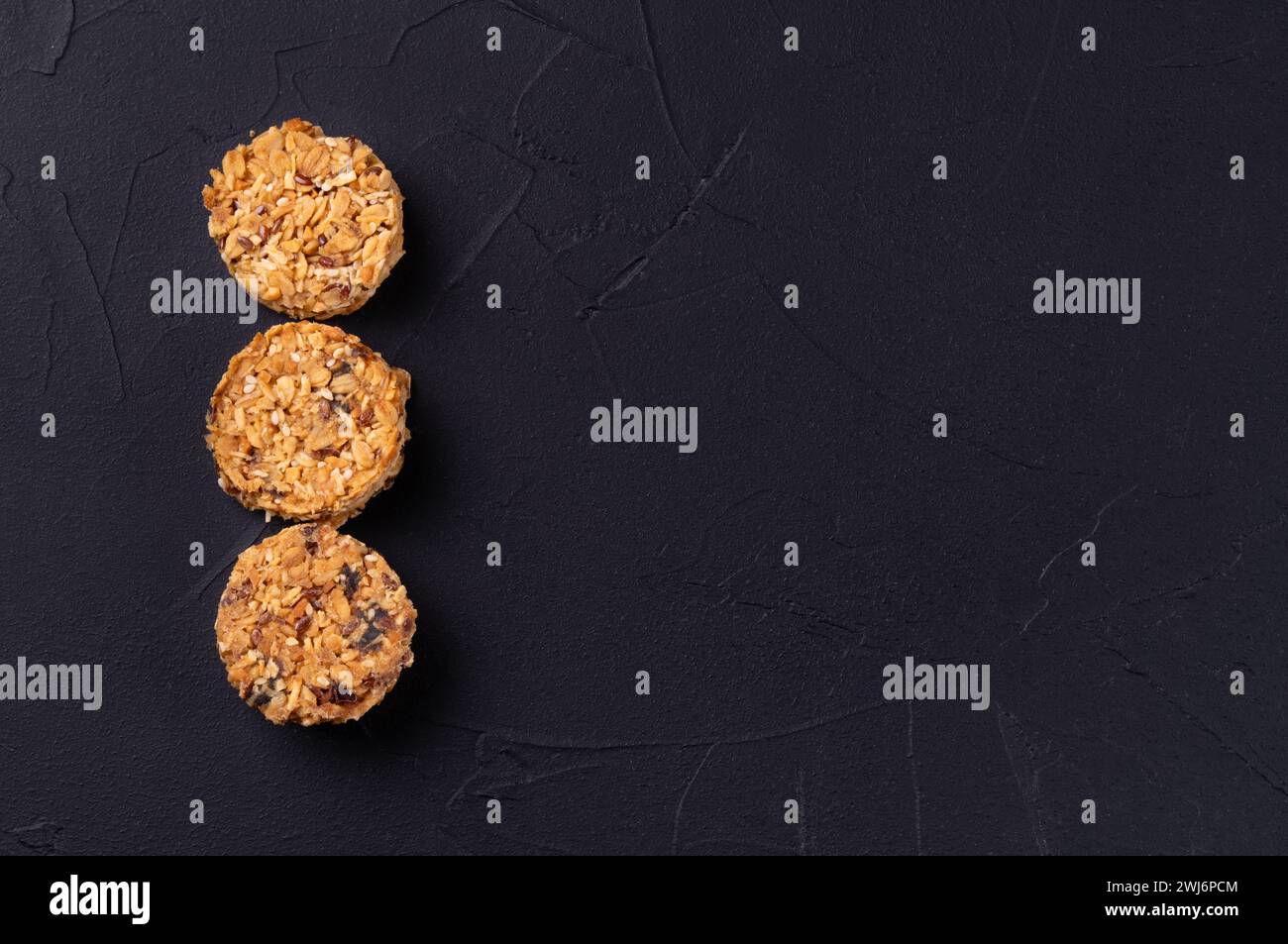 Three granola cookies made from healthy cereals and grains on a dark ...