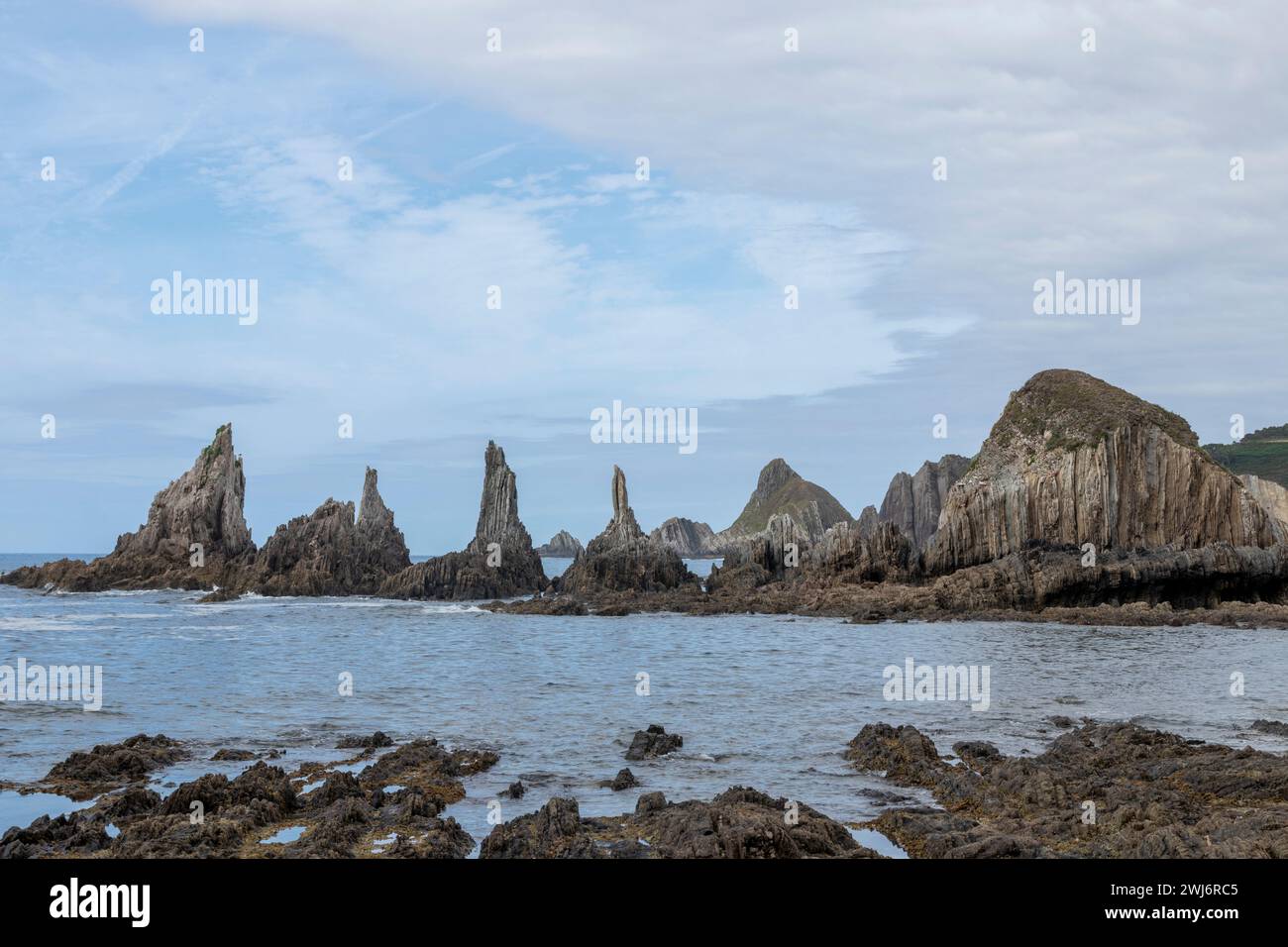scenic view of jagged rock formations amidst the sea, under a sky with ...