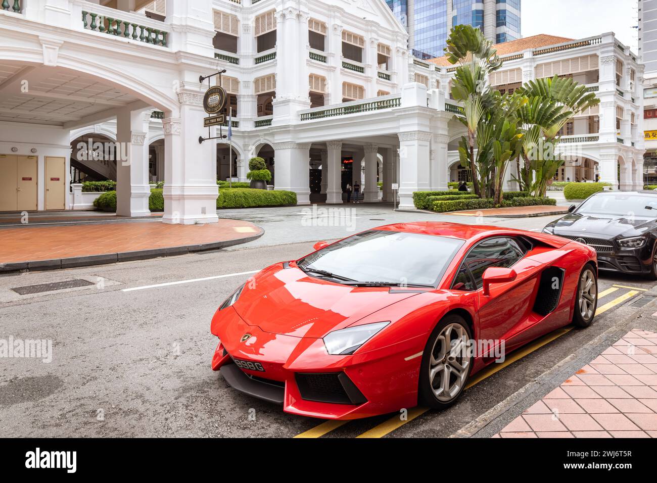 Raffles Hotel in Singapore with red Lamborghini supercar parked outside ...
