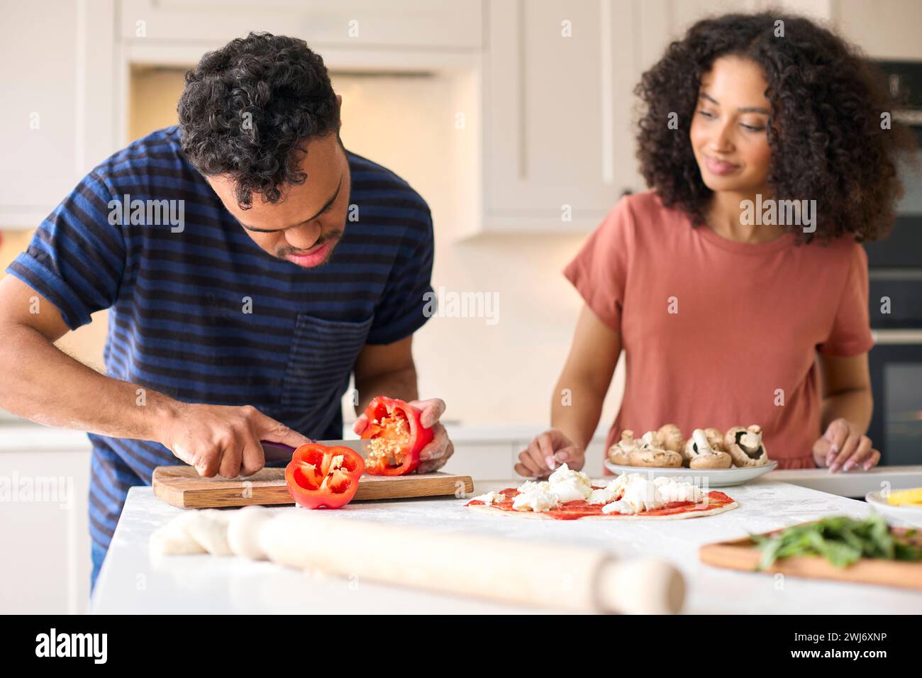 Couple At Home With Man With Down Syndrome And Woman Preparing Topping ...