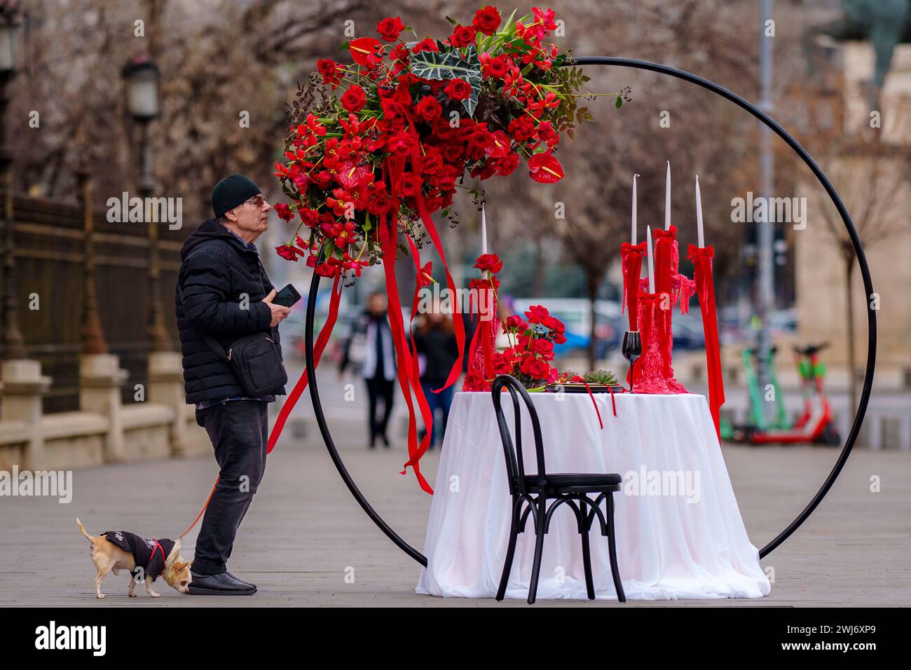 A man stops to smell the flowers in a Valentine's Day installation ...