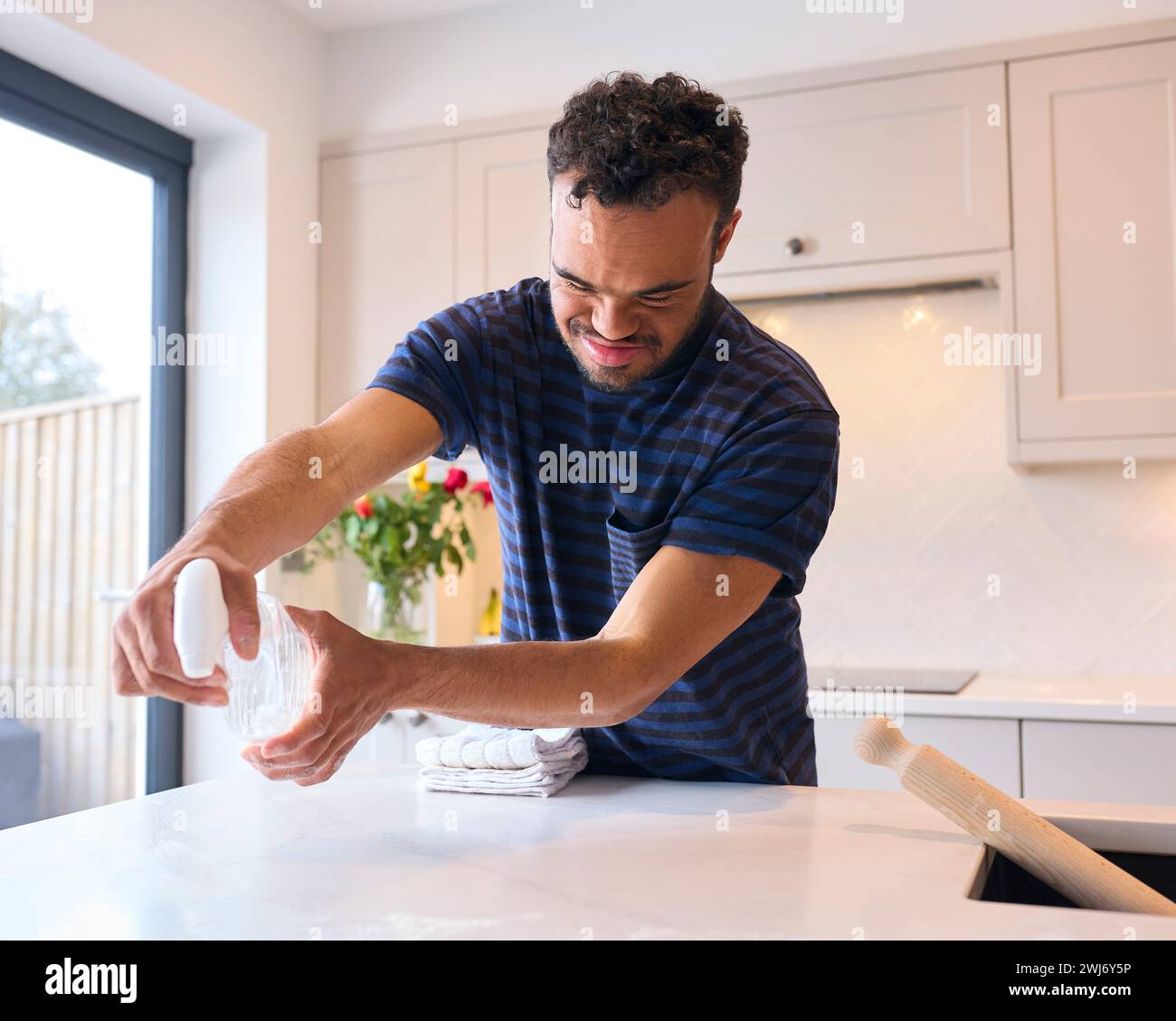 Man With Down Syndrome Cleaning And Clearing Up After Meal In Kitchen ...