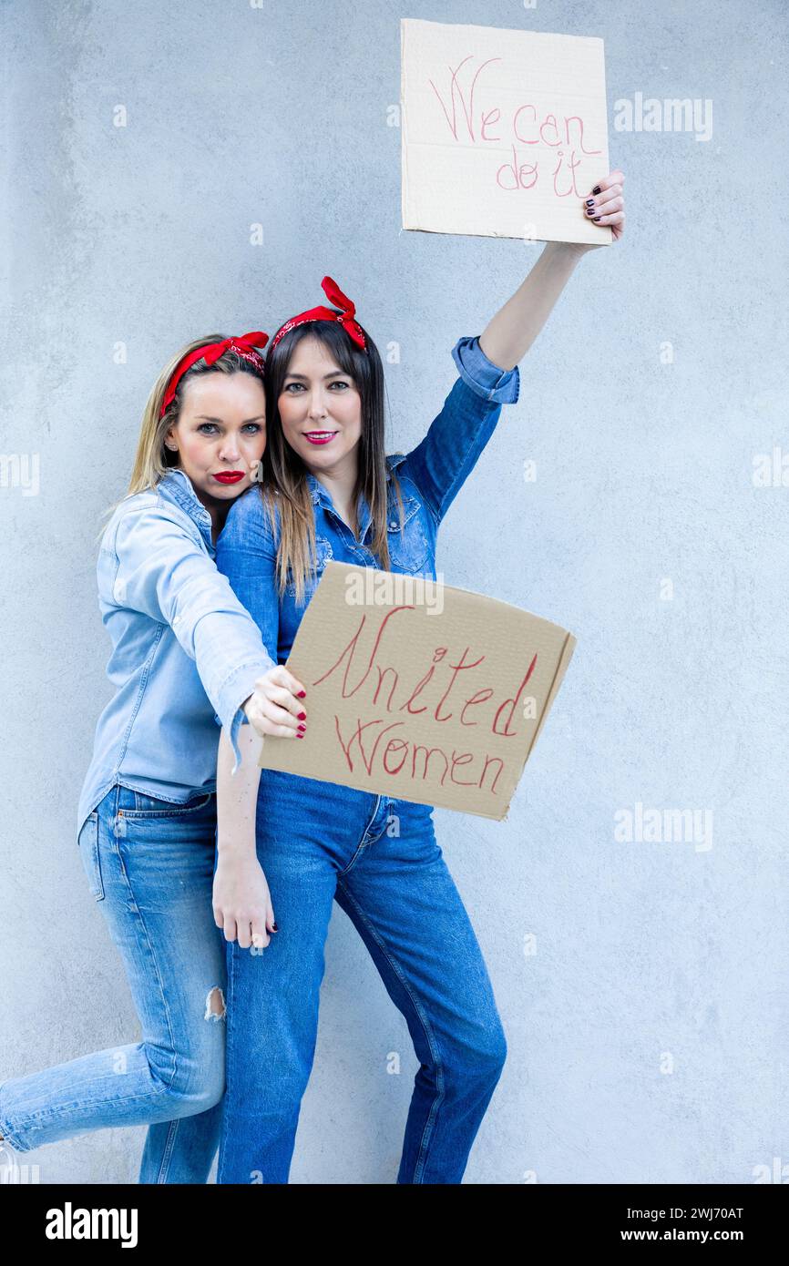 Two women stand close, confidently holding signs that read 'United ...