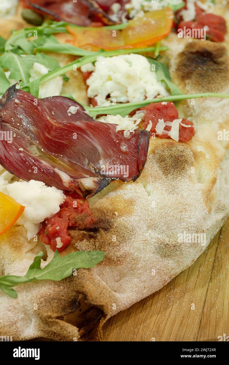 Traditional pizza with prosciutto, tomatoes and mozzarella topping ...