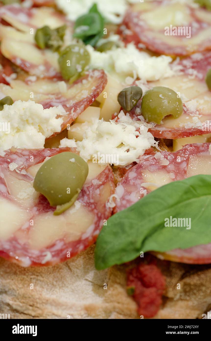 Traditional pizza with pepperoni sausage, olives and mozzarella topping ...