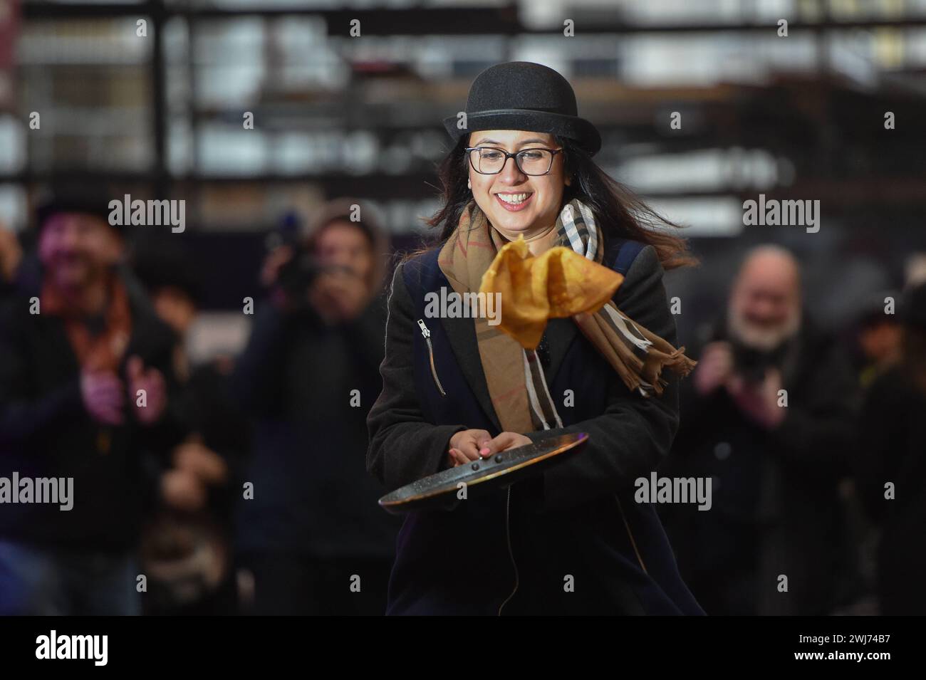 London, England, UK. 13th Feb, 2024. Competitors flip pancakes in the ...