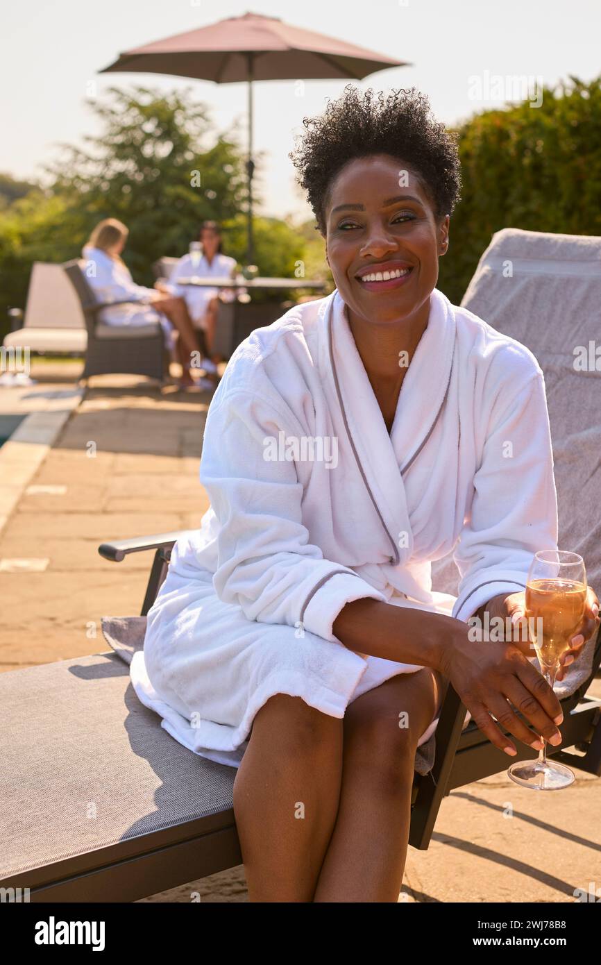 Portrait Of Mature Woman Wearing Robe Outdoors On Lounger Drinking ...