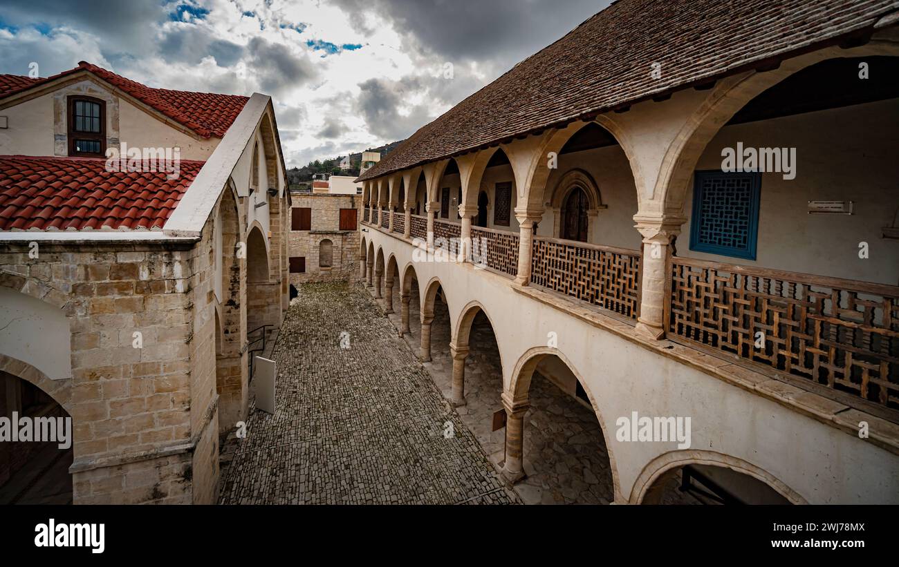 Long, narrow pathway in an aged brick building alongside imposing stone ...