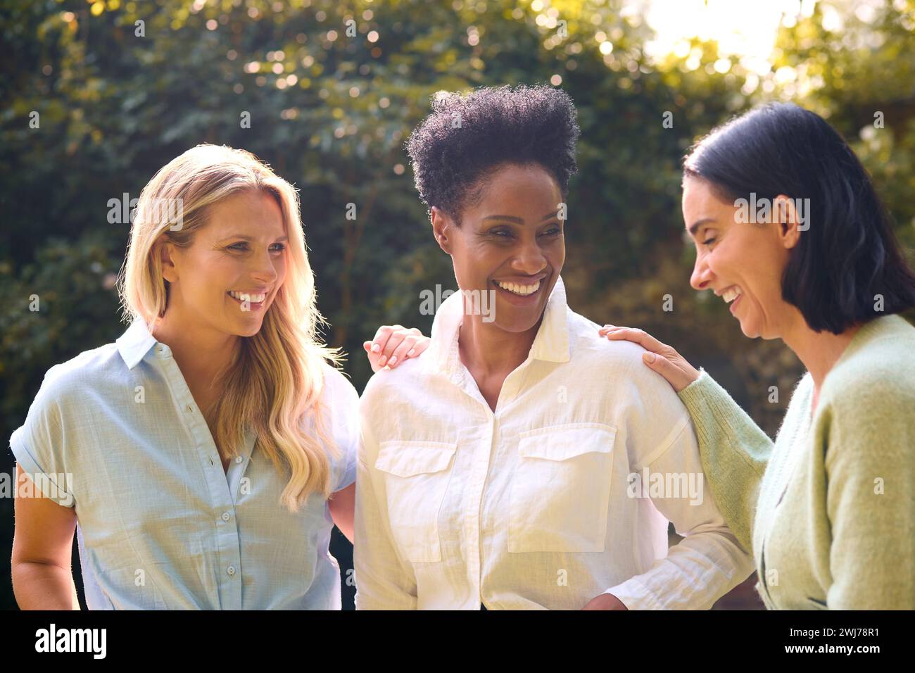 Three Smiling Mature Female Friends Outdoors Spending Time In ...