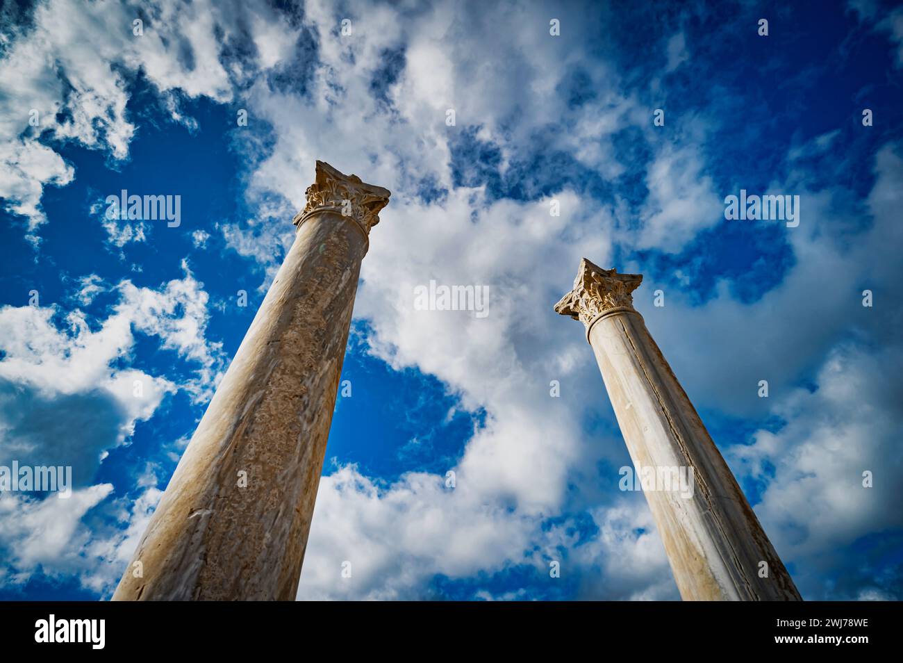 Three weathered columns stand in an ancient ruin, framed by a ...