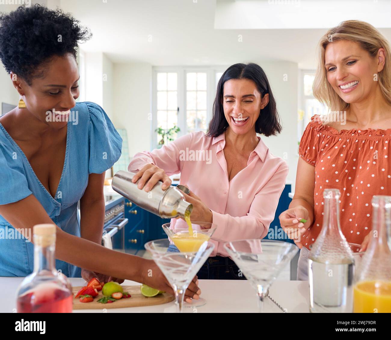 Three Mature Female Friends At Home Having Fun Mixing Cocktails ...