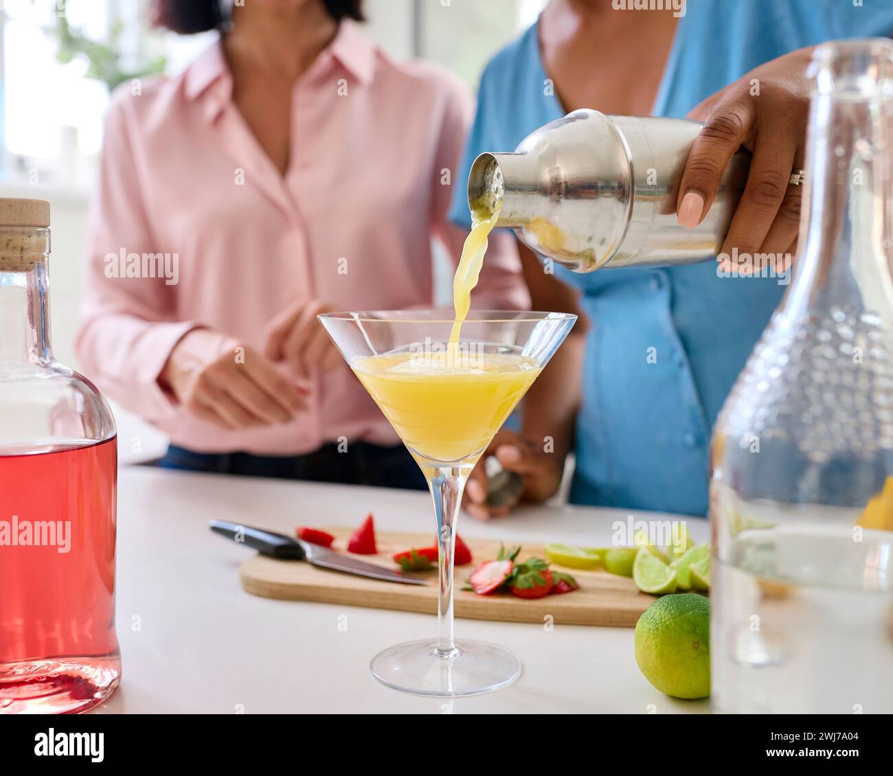 Close Up Of Female Friends At Home Having Fun Pouring Cocktails Into ...