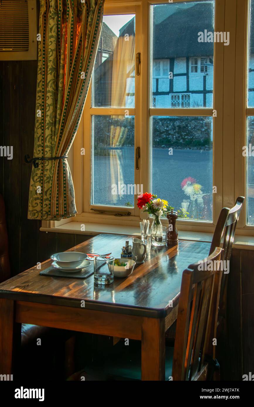 The interior of a public house which is warm and inviting with tables ...