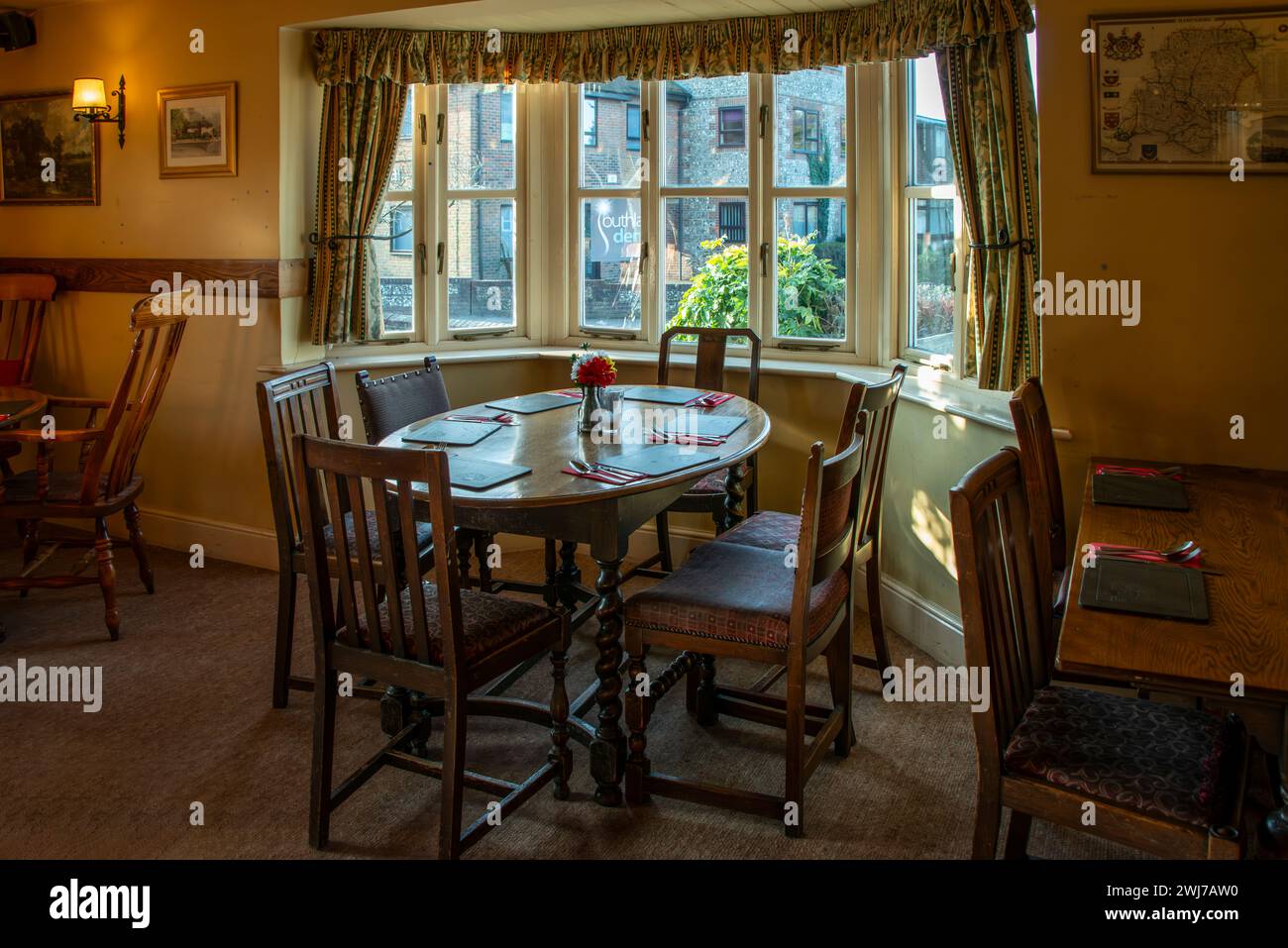 The interior of a public house which is warm and inviting with tables ...