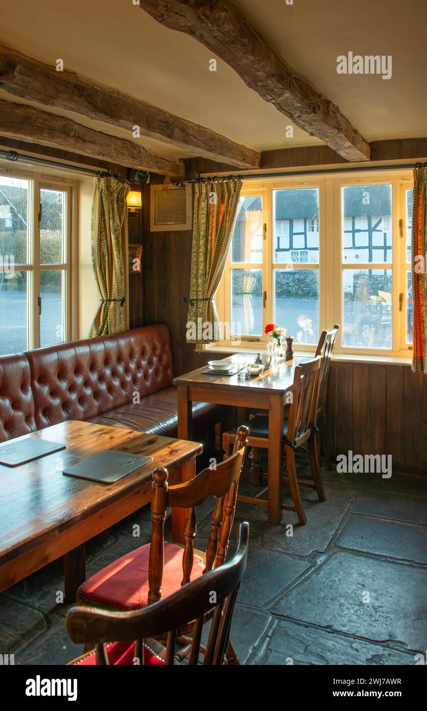 The interior of a public house which is warm and inviting with tables ...
