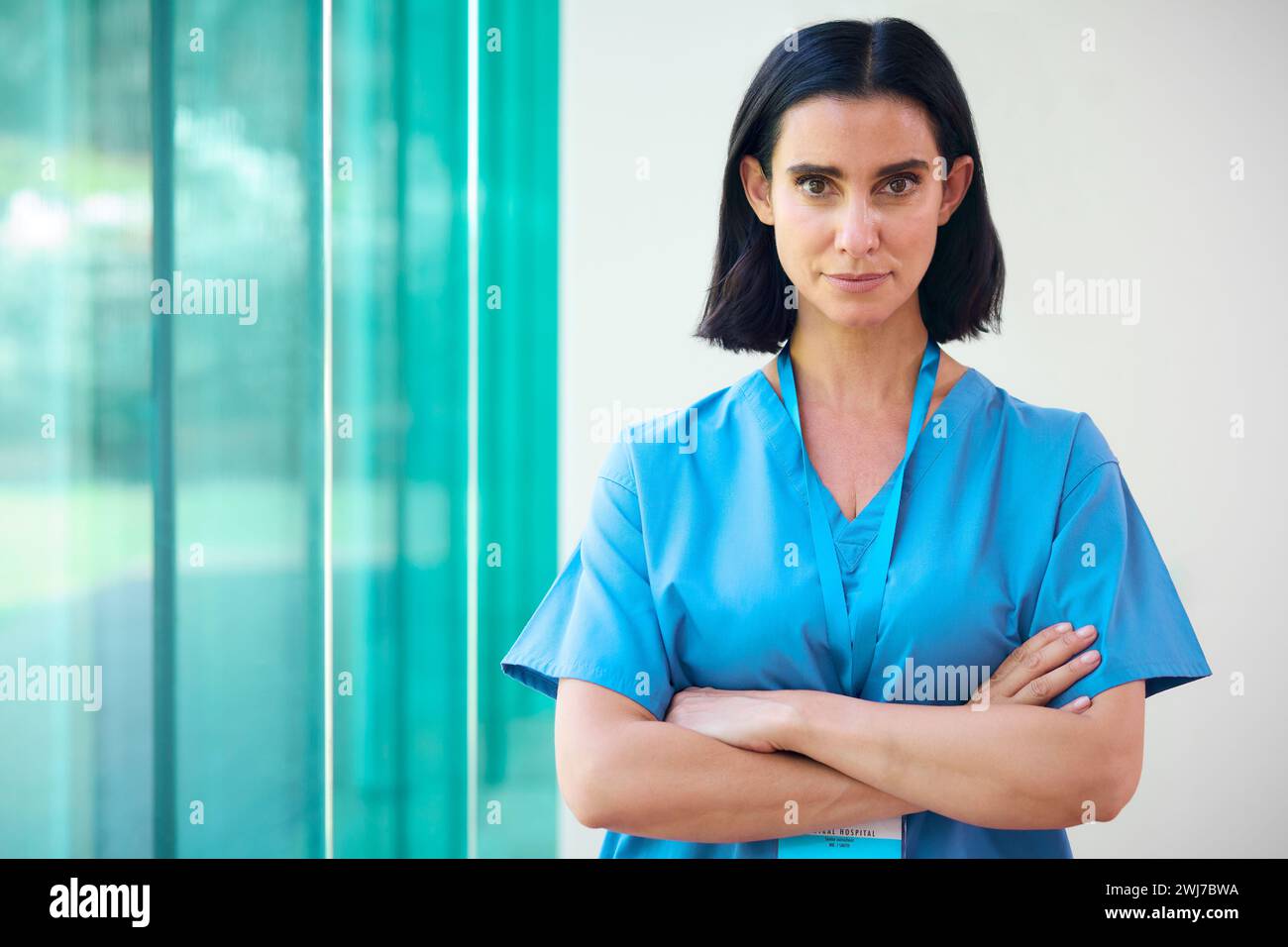 Portrait Of Mature Serious Female Doctor With Security Lanyard Wearing ...