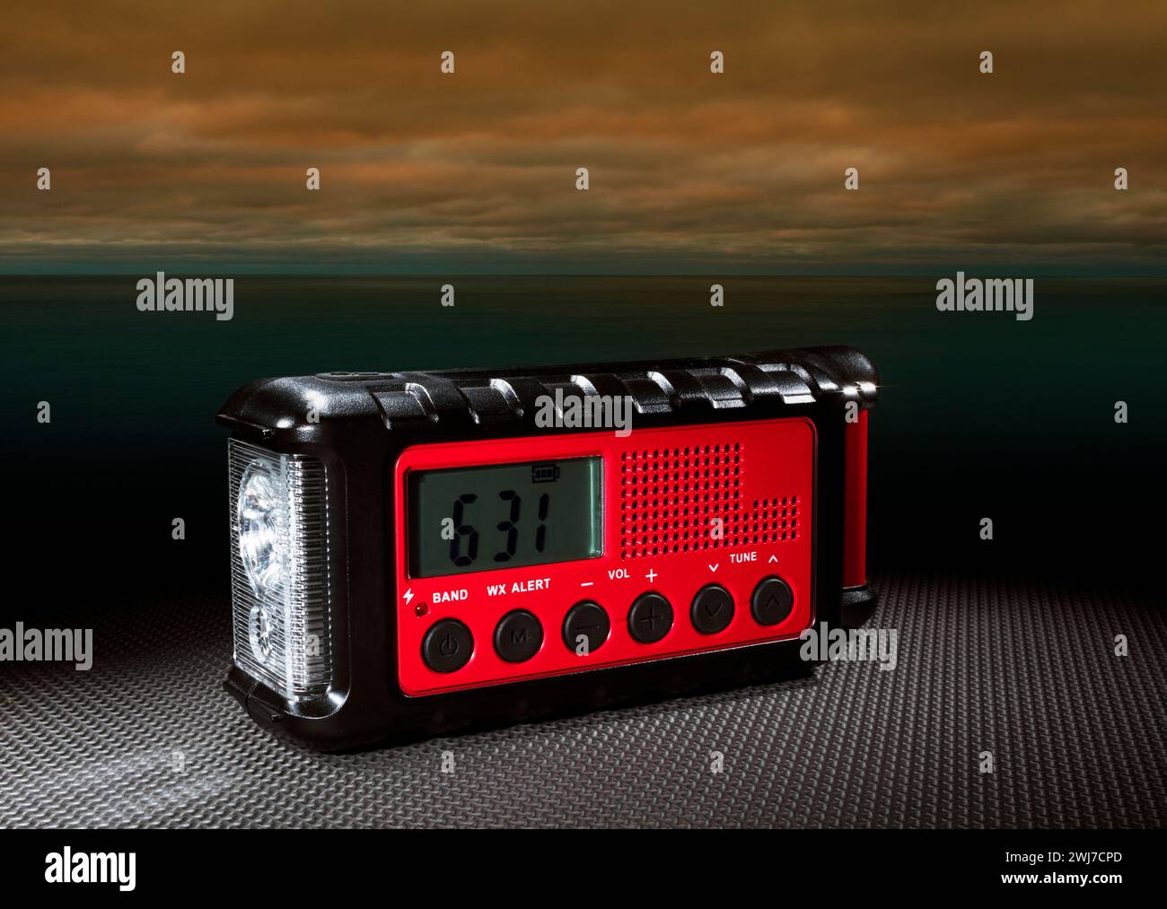 Weather radio with flashlight and clock with threatening skies in the ...