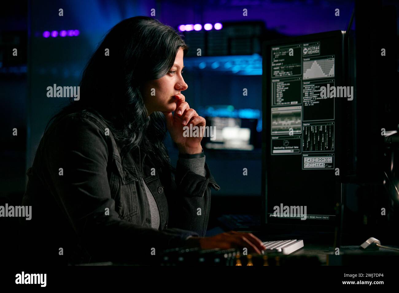 Low Key Lighting Shot Of Female Computer Hacker Sitting In Front Of ...