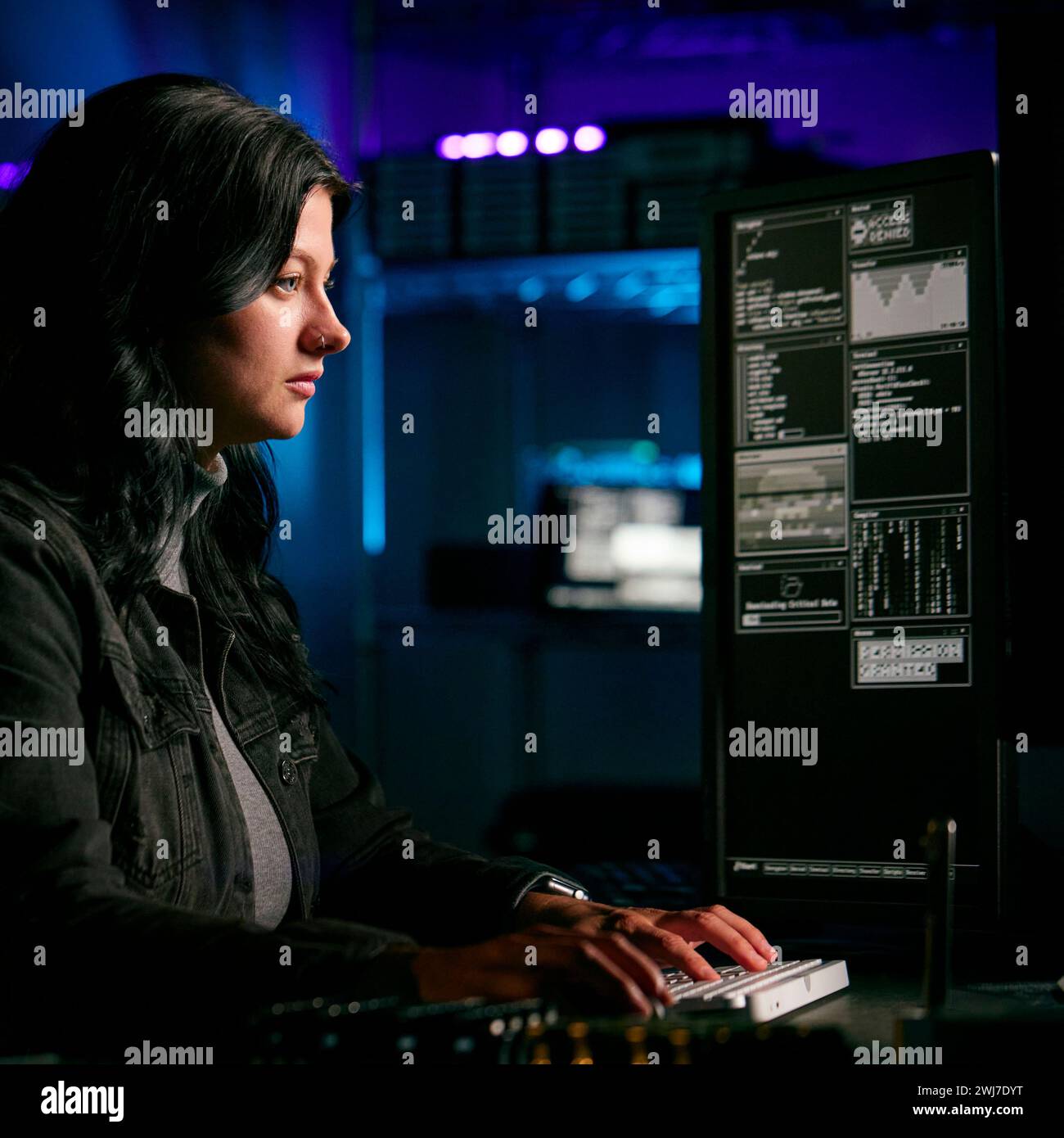Low Key Lighting Shot Of Female Computer Hacker Sitting In Front Of ...