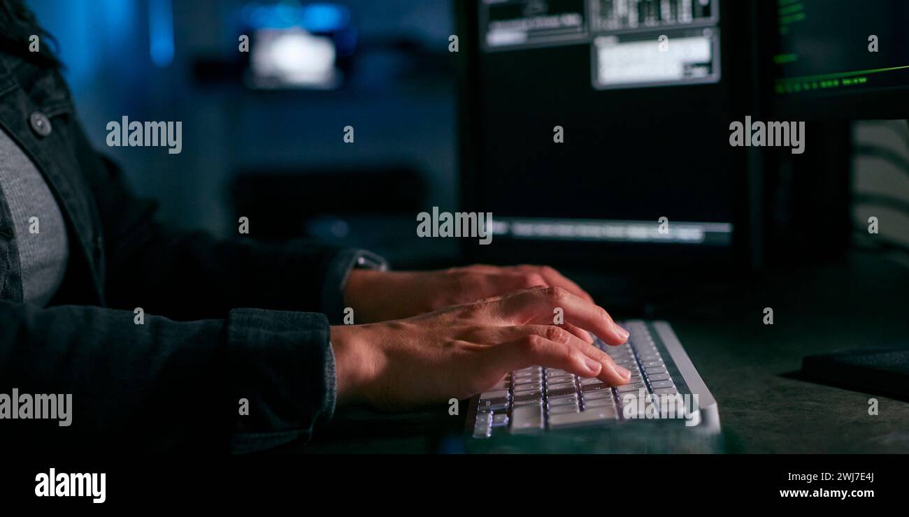 Close Up On Hands Of Female Computer Hacker Sitting In Front Of Screens Breaching Cyber Security ...
