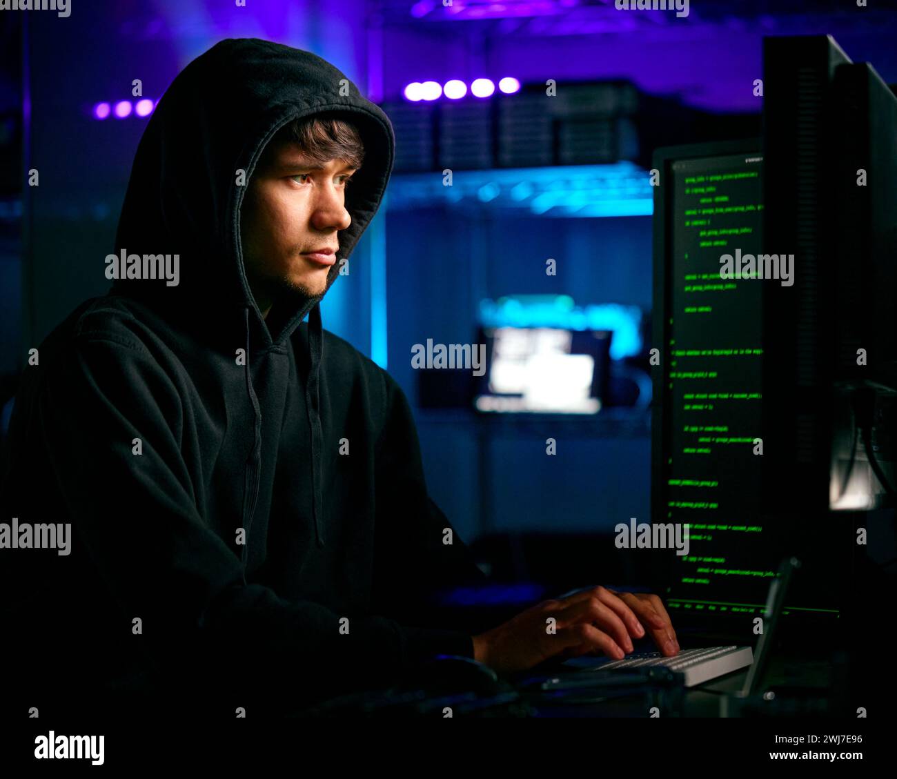 Low Key Lighting Shot Of Male Computer Hacker Sitting In Front Of ...