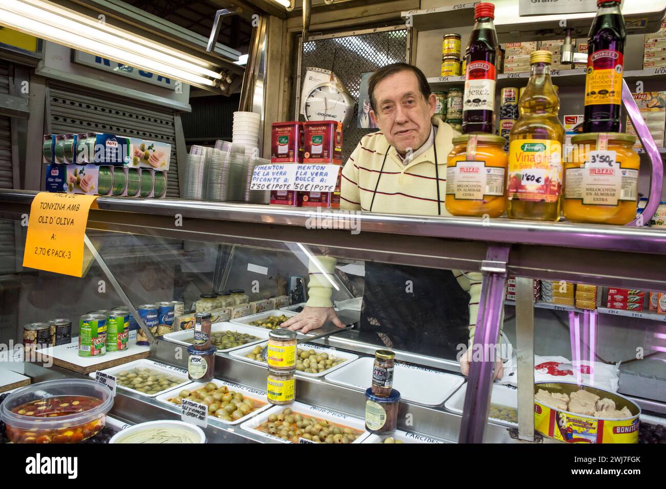 Portrait of the owner of an olives and canned food stall in the old ...
