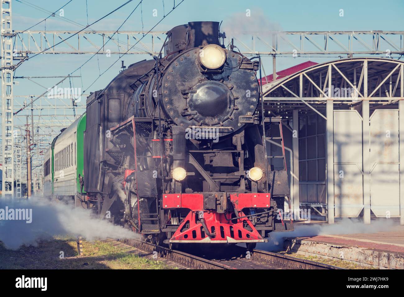 Retro steam train approaches to the platform Stock Photo - Alamy