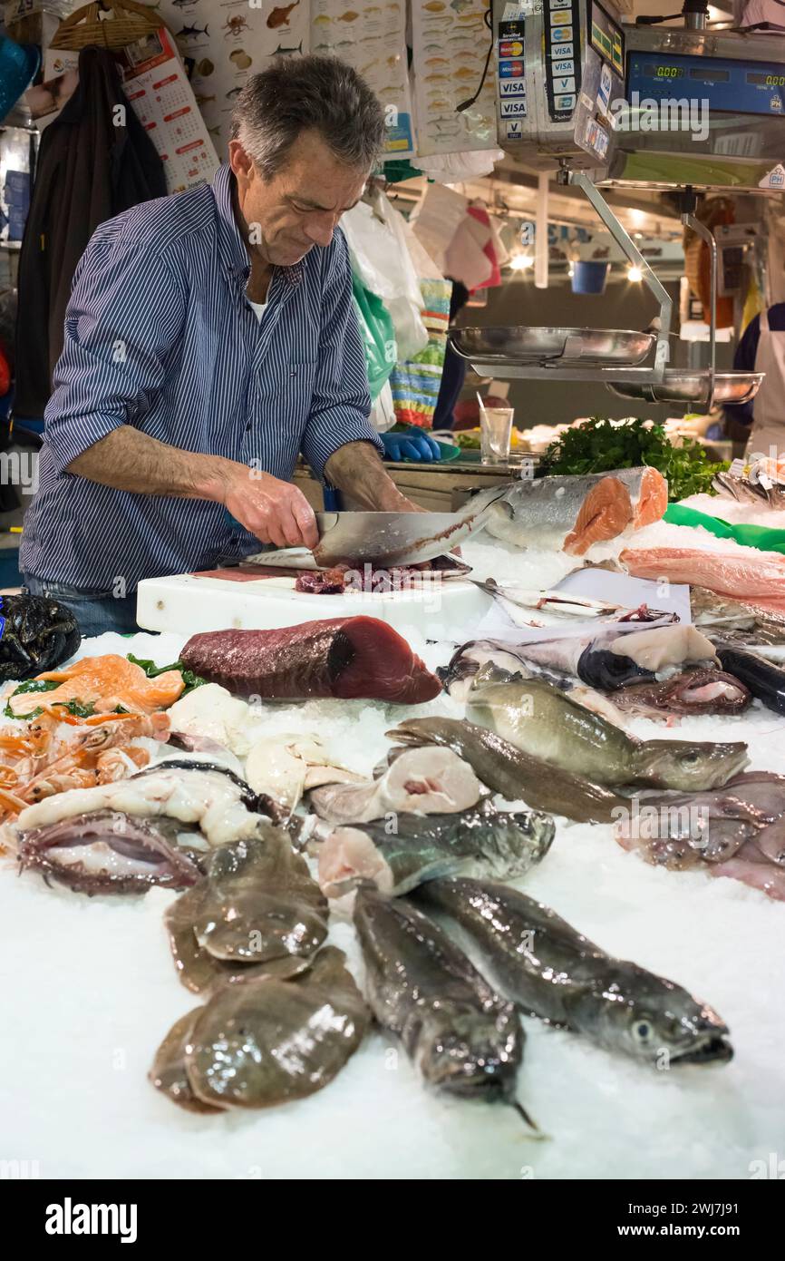 Fishmonger cutting fish of the old Abaceria Central Market in Barcelona ...