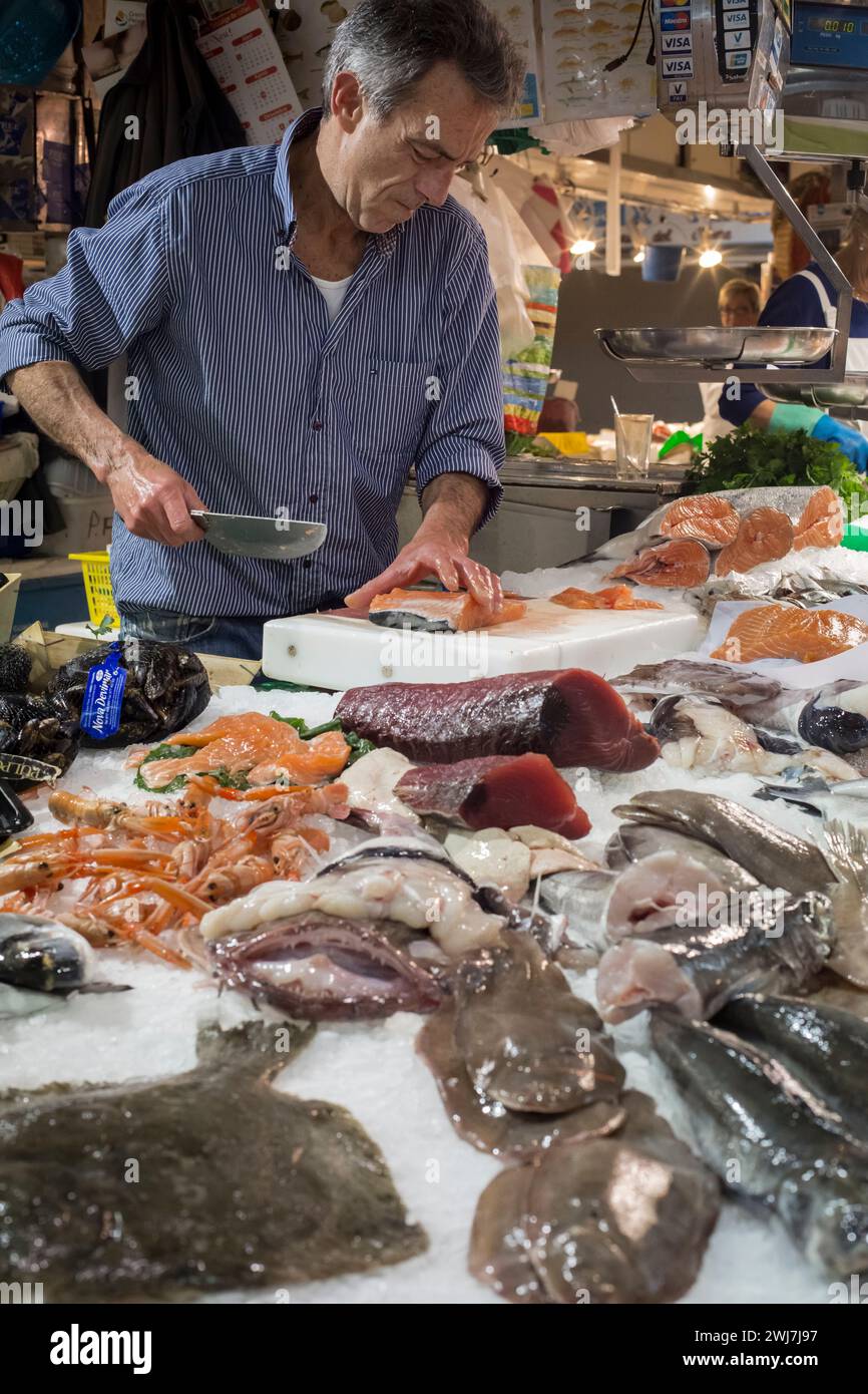 Fishmonger cutting salmon of the old Abaceria Central Market in ...