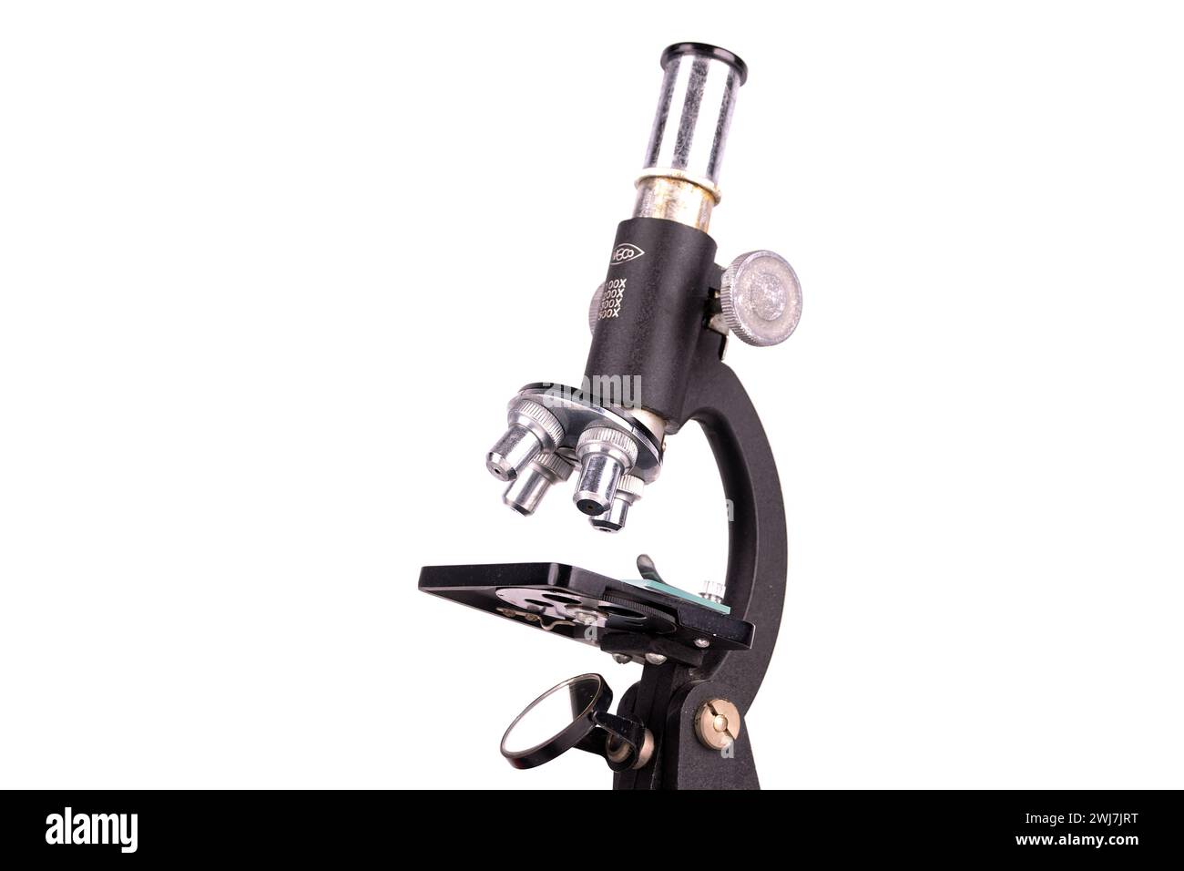 an old microscope stands isolated on a white background on a white ...