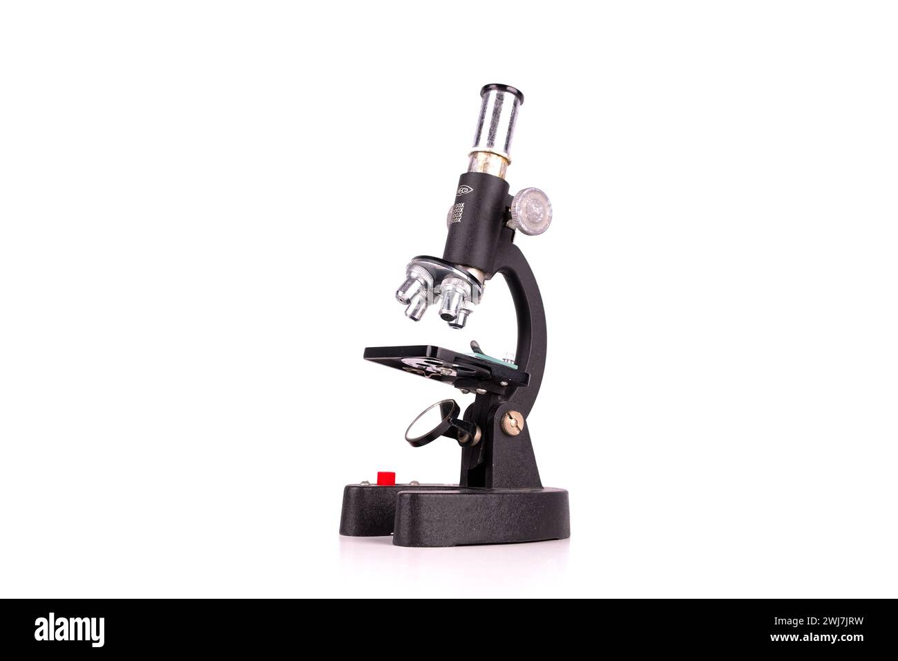 an old microscope stands isolated on a white background on a white ...