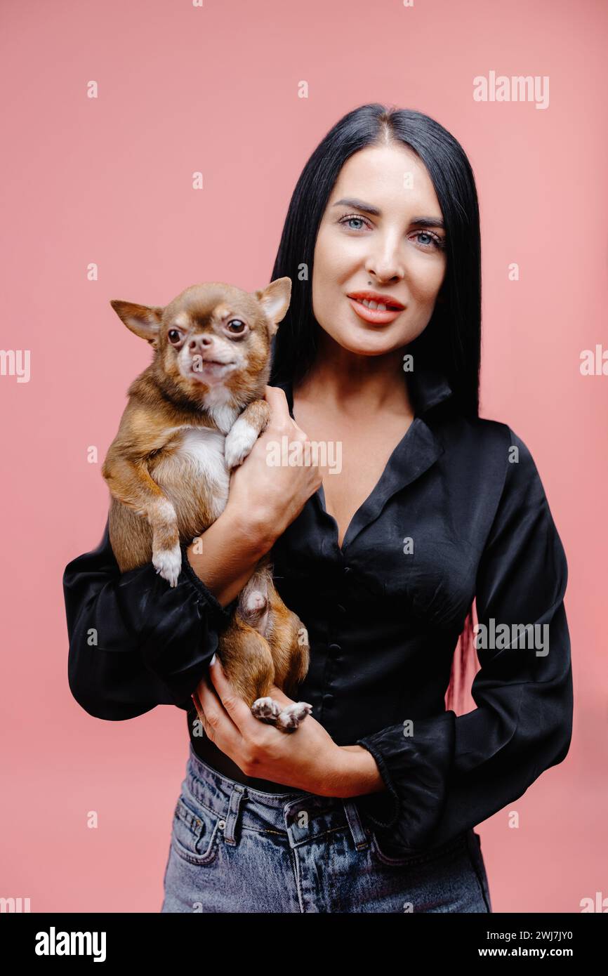 Wonderful european female model chilling in studio with puppy. Indoor ...