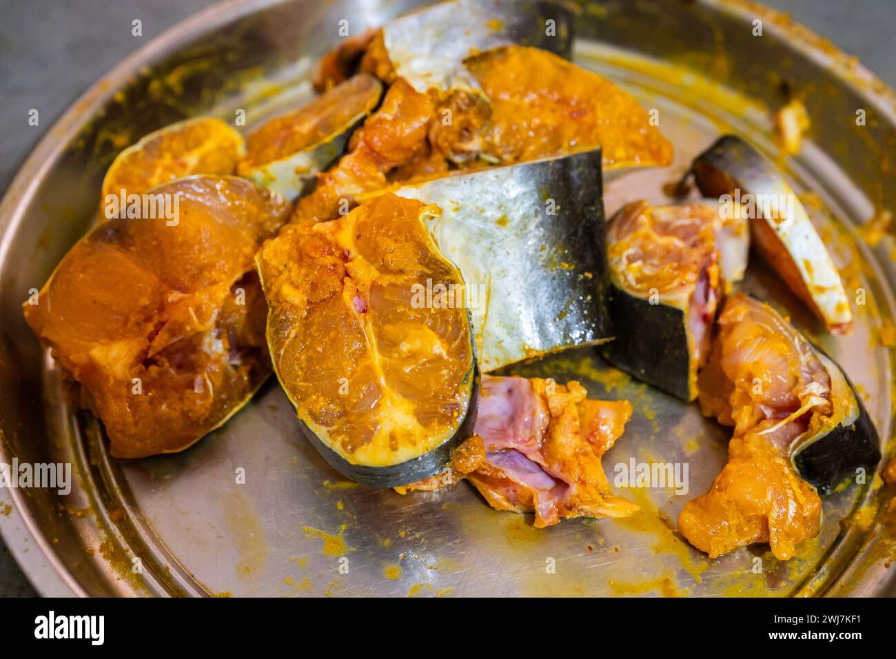 fresh fish marinating in spices at home in plat from different angle ...