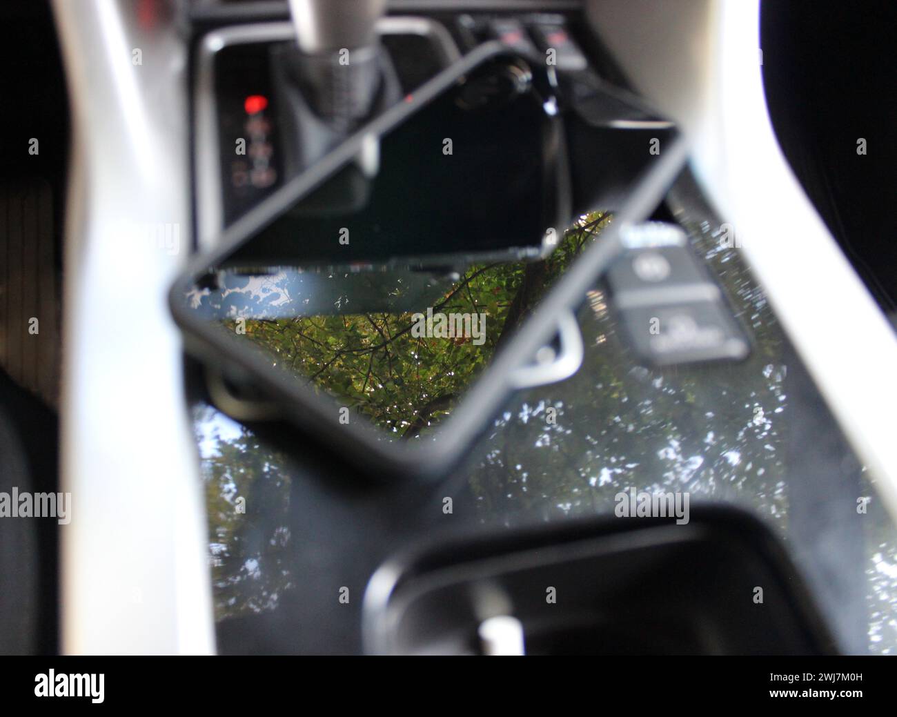 Mobile Phone With Reflection Of Green Leaves On A Screen Near Gear ...