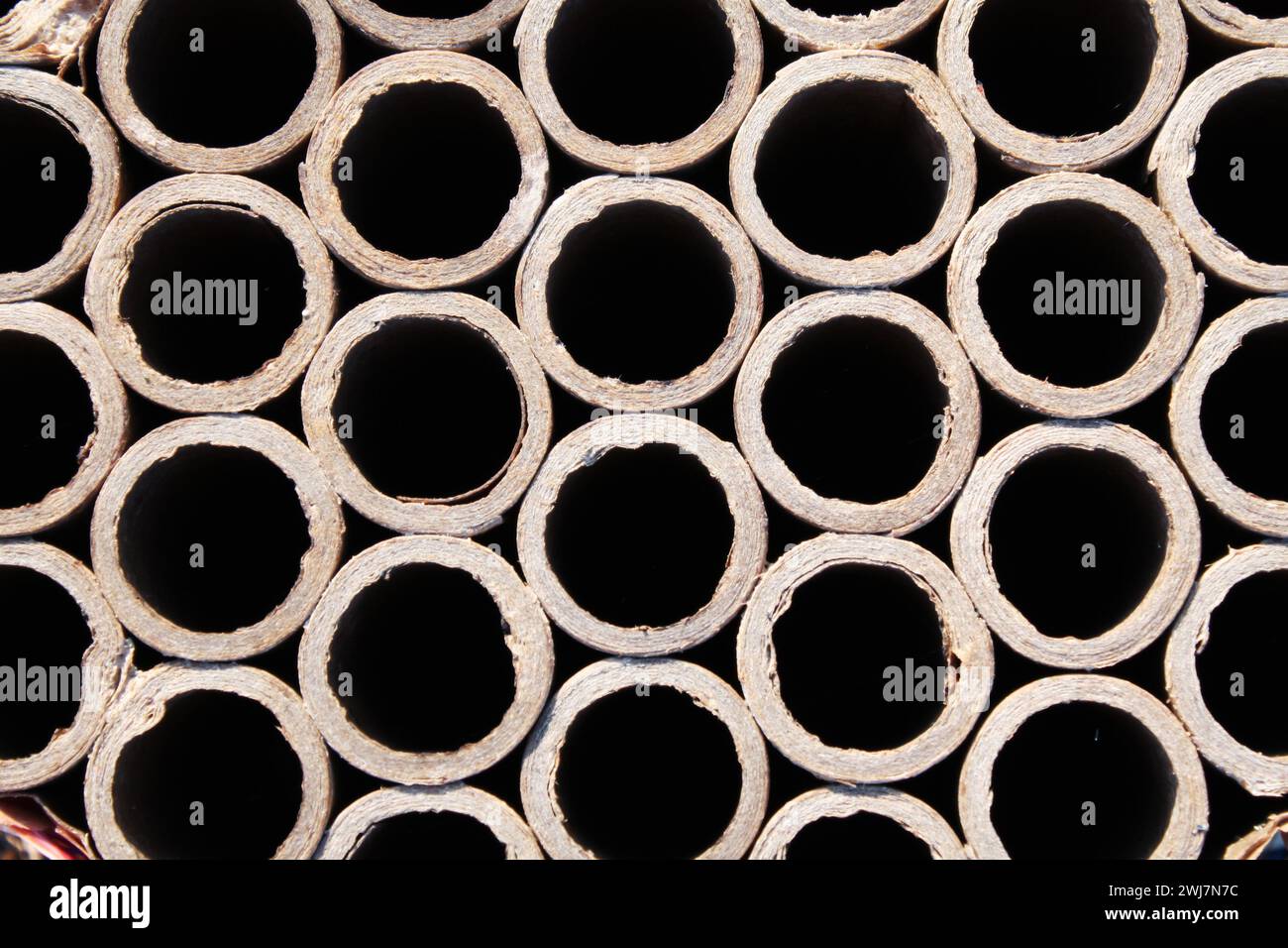 Close-up of circular, hollow, aged cardboard tubes arranged neatly ...