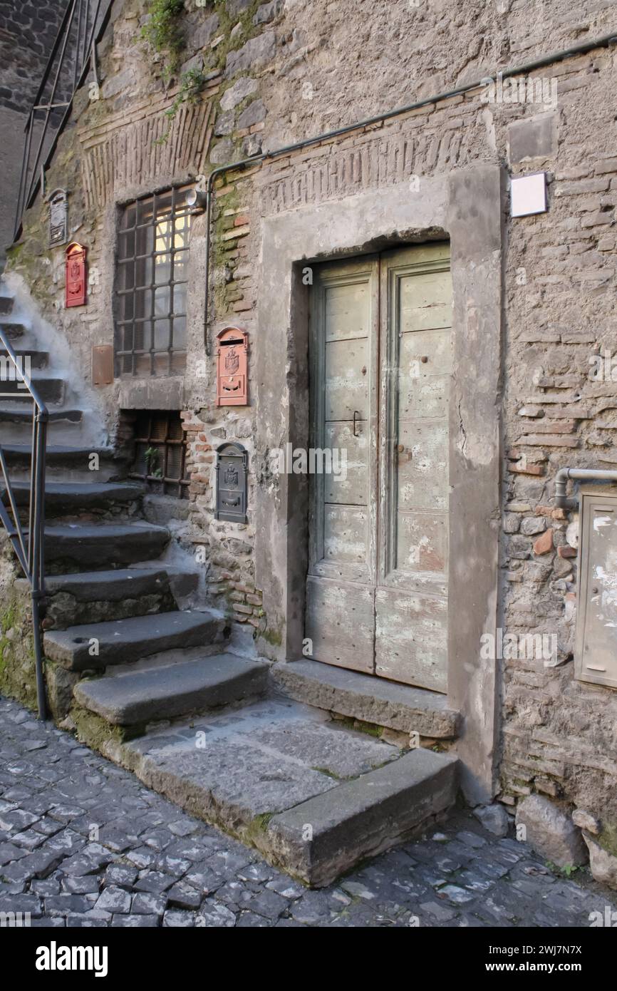 Rustic scene with old weathered door, stone stairs, textured wall with ...