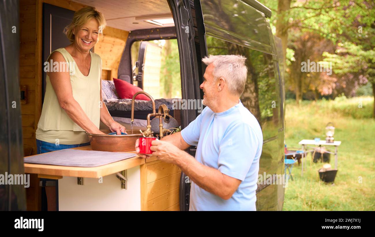 Senior Couple Enjoying Camping In Countryside Relaxing Inside RV And ...
