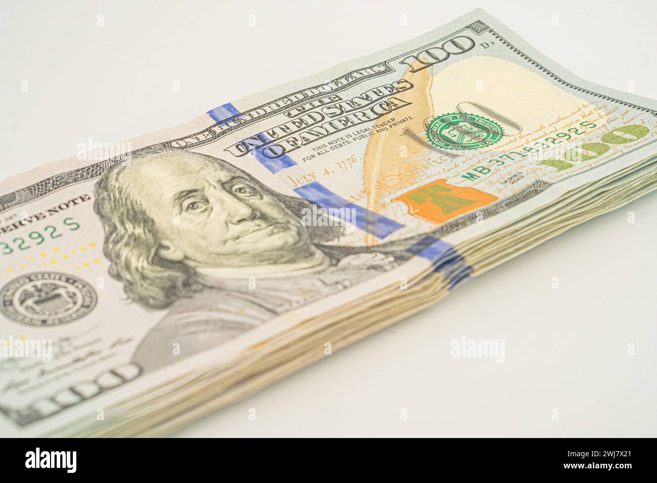 Several 100 dollar bills are stacked up. Dollars pack isolated on white ...