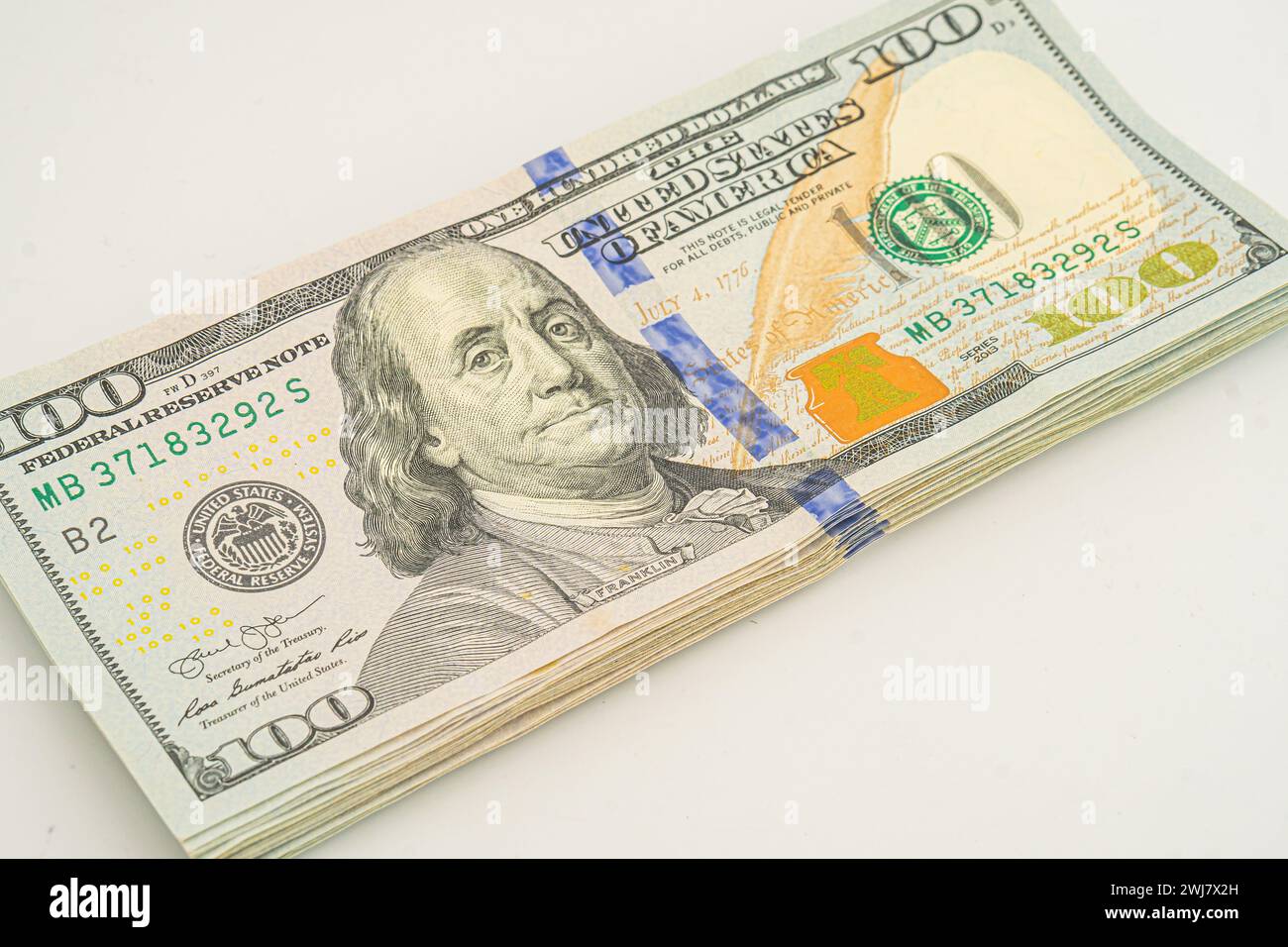 Several 100 dollar bills are stacked up. Dollars pack isolated on white ...