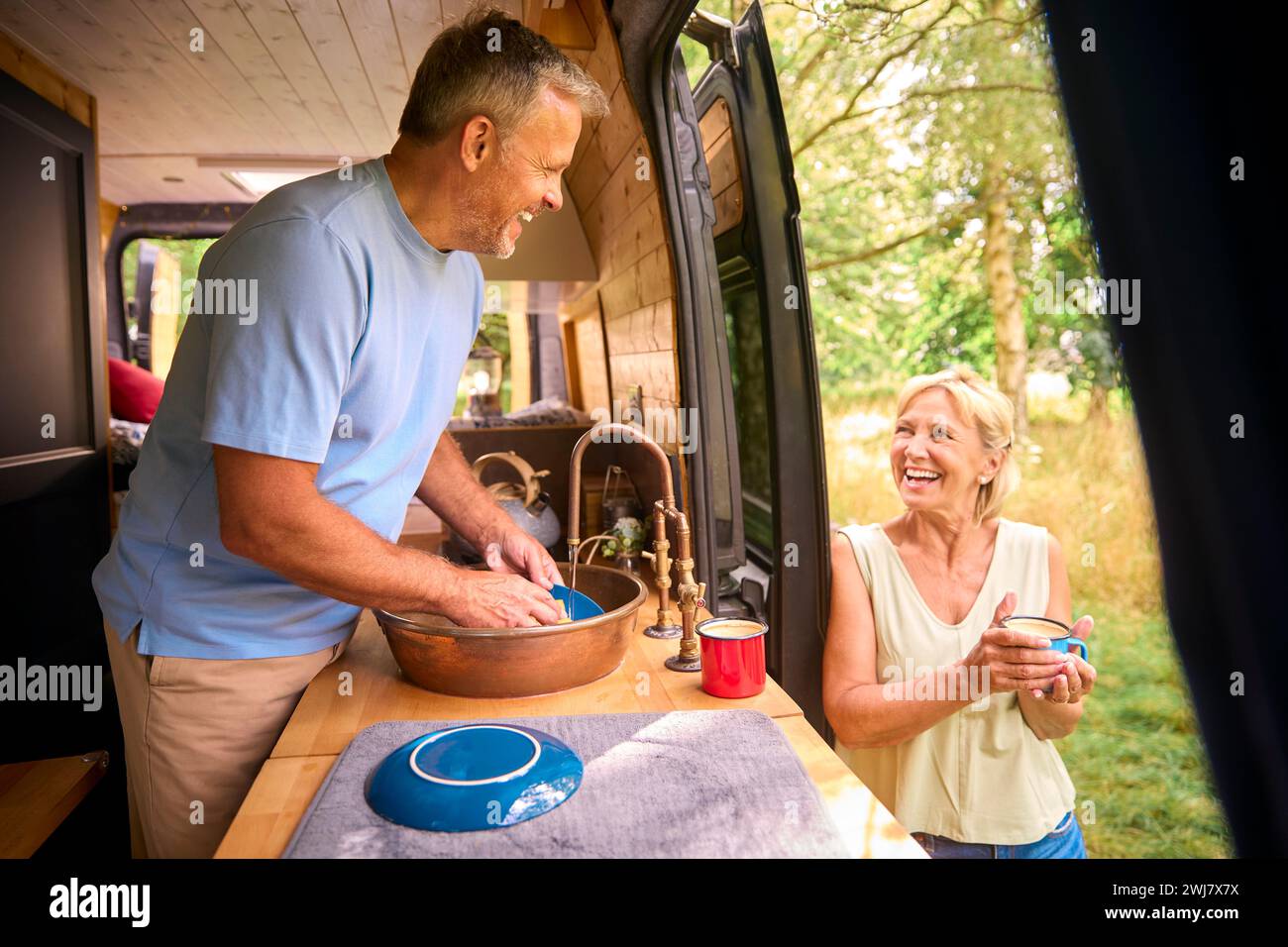 Senior Couple Enjoying Camping In Countryside Relaxing Inside RV And ...
