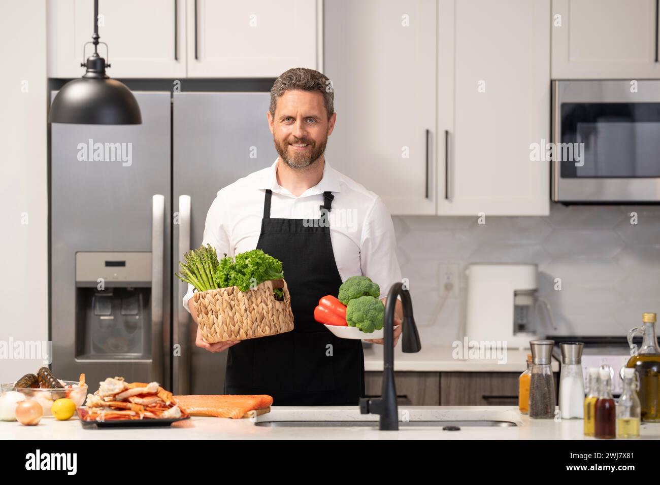 Hispanic man in kitchen preparing food. Millennial man cook healthy ...