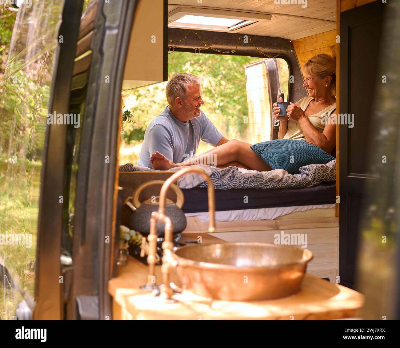 Senior Couple Camping In Countryside Relaxing Drinking Coffee Inside RV ...