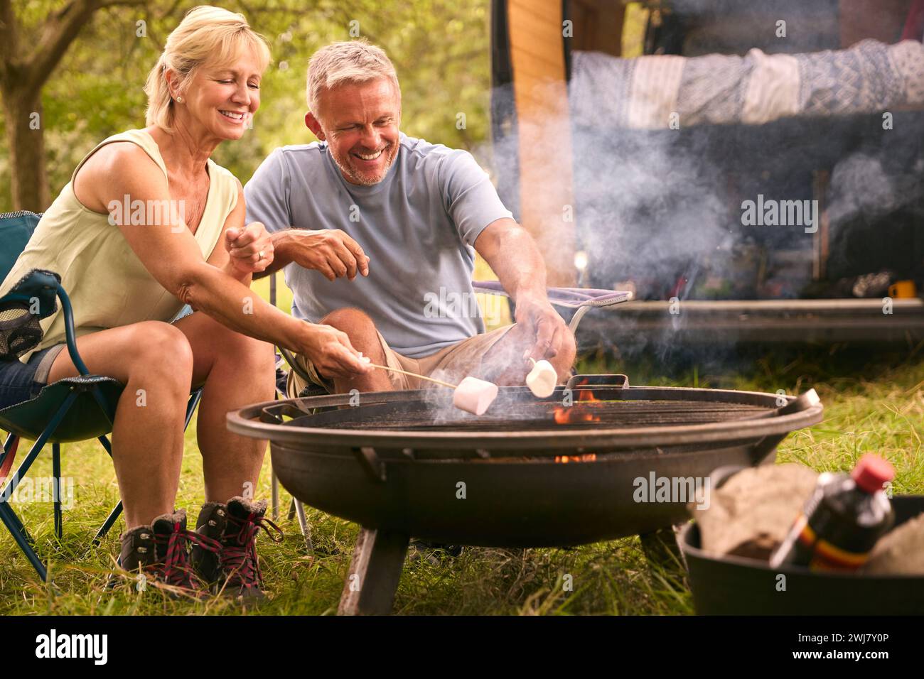 Senior Couple Camping In Countryside With RV Toasting Marshmallows ...