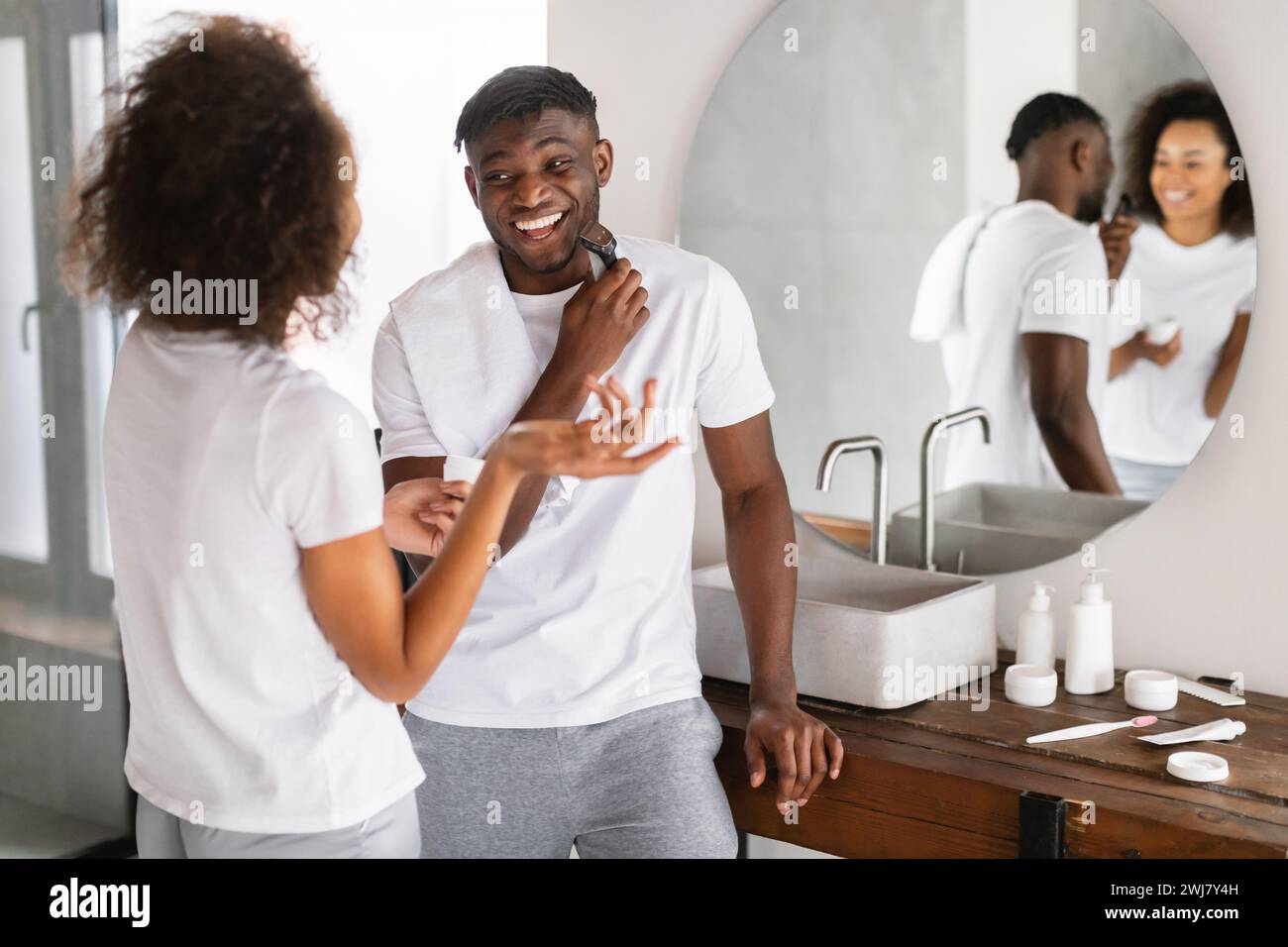 black couple talking and laughing while husband shaving in bathroom ...