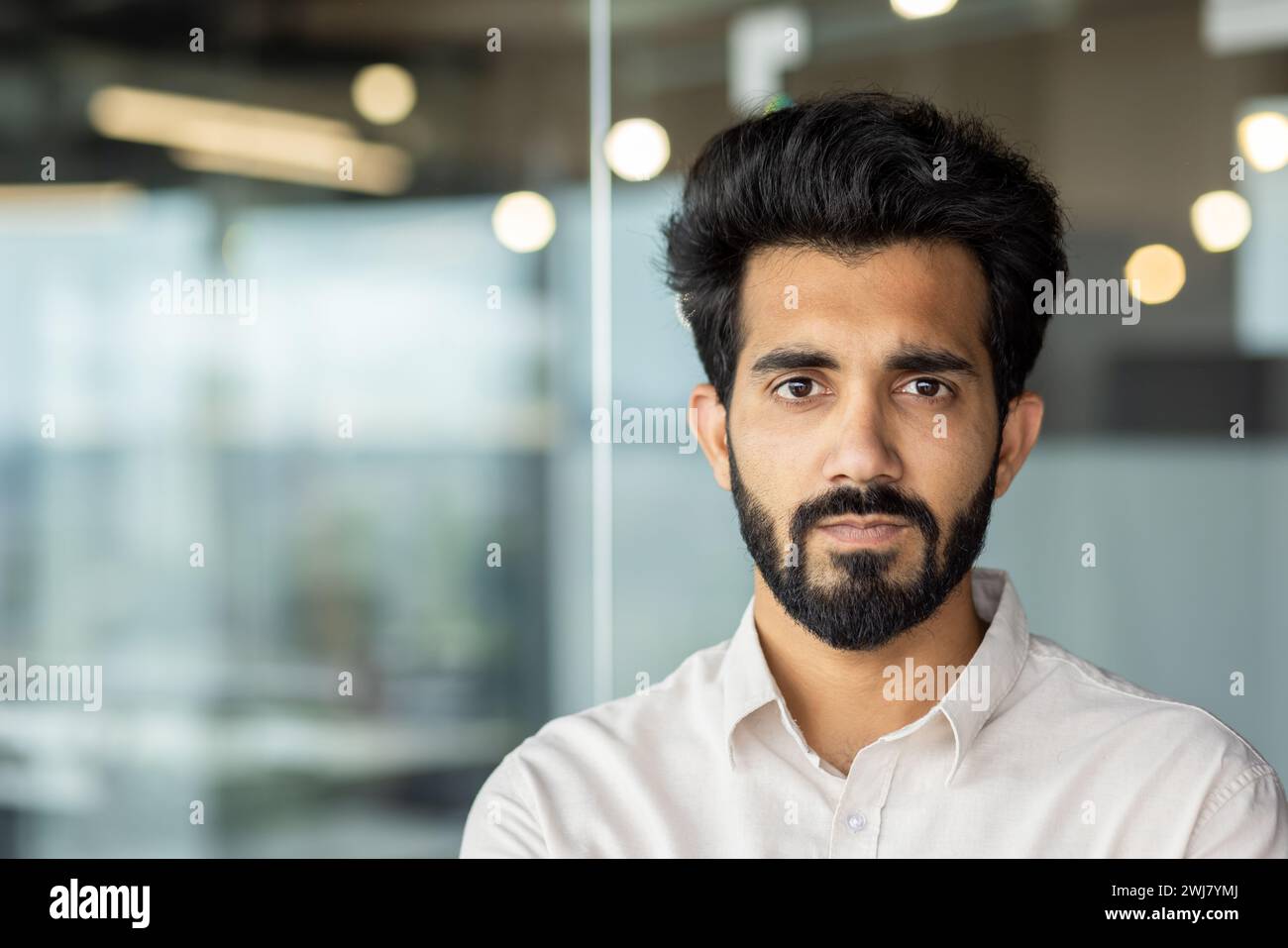 Portrait of a serious and confident Indian man standing in a shirt in ...