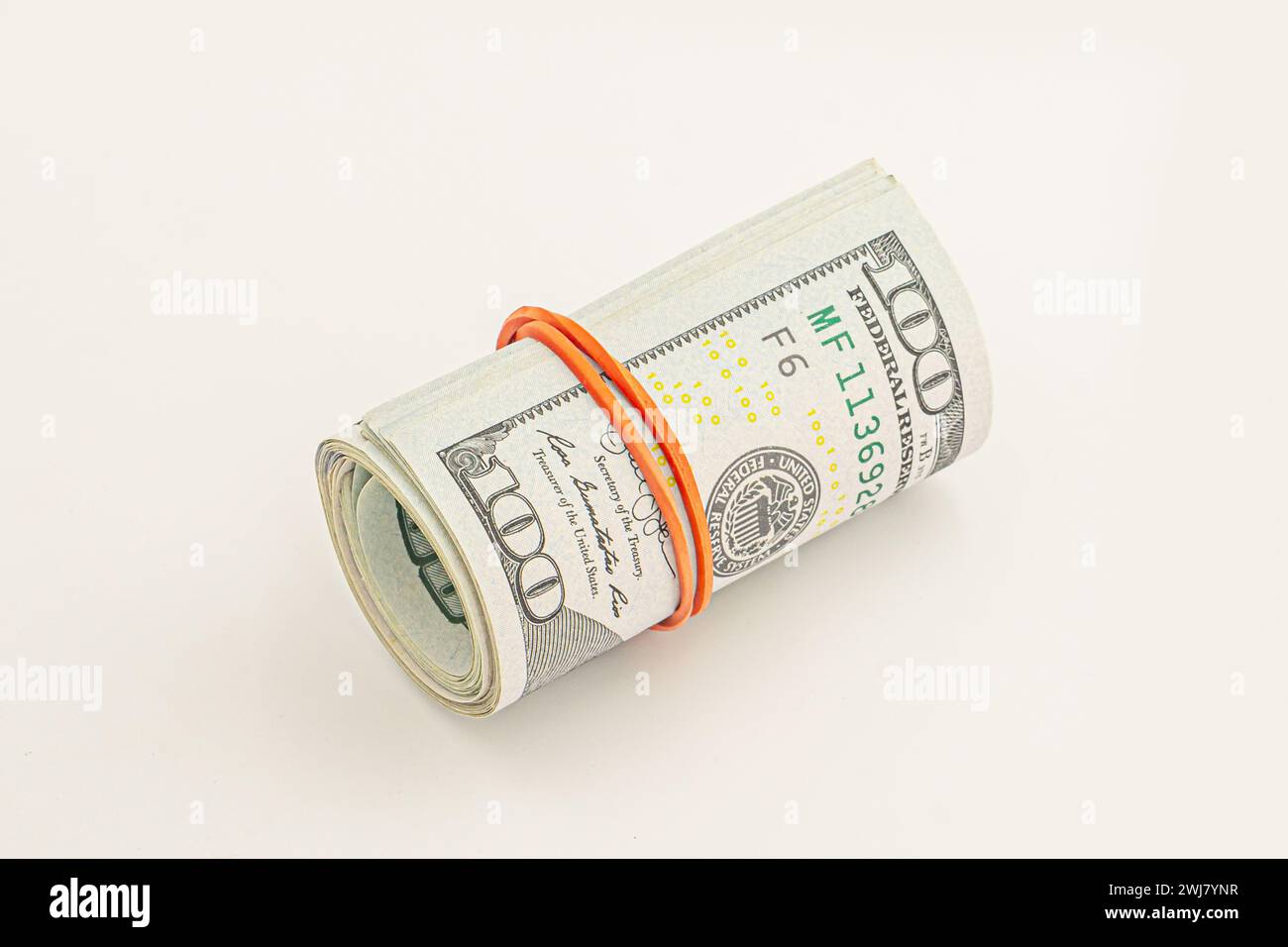 100 dollar bills on a roll isolated on white background. Rolled up ...