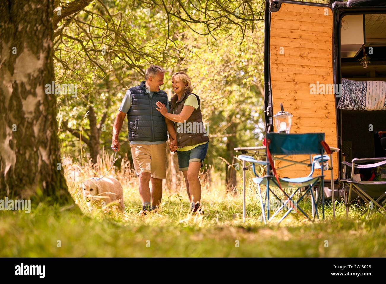 Senior Couple Camping In Countryside With RV Taking Labrador Dog For A ...