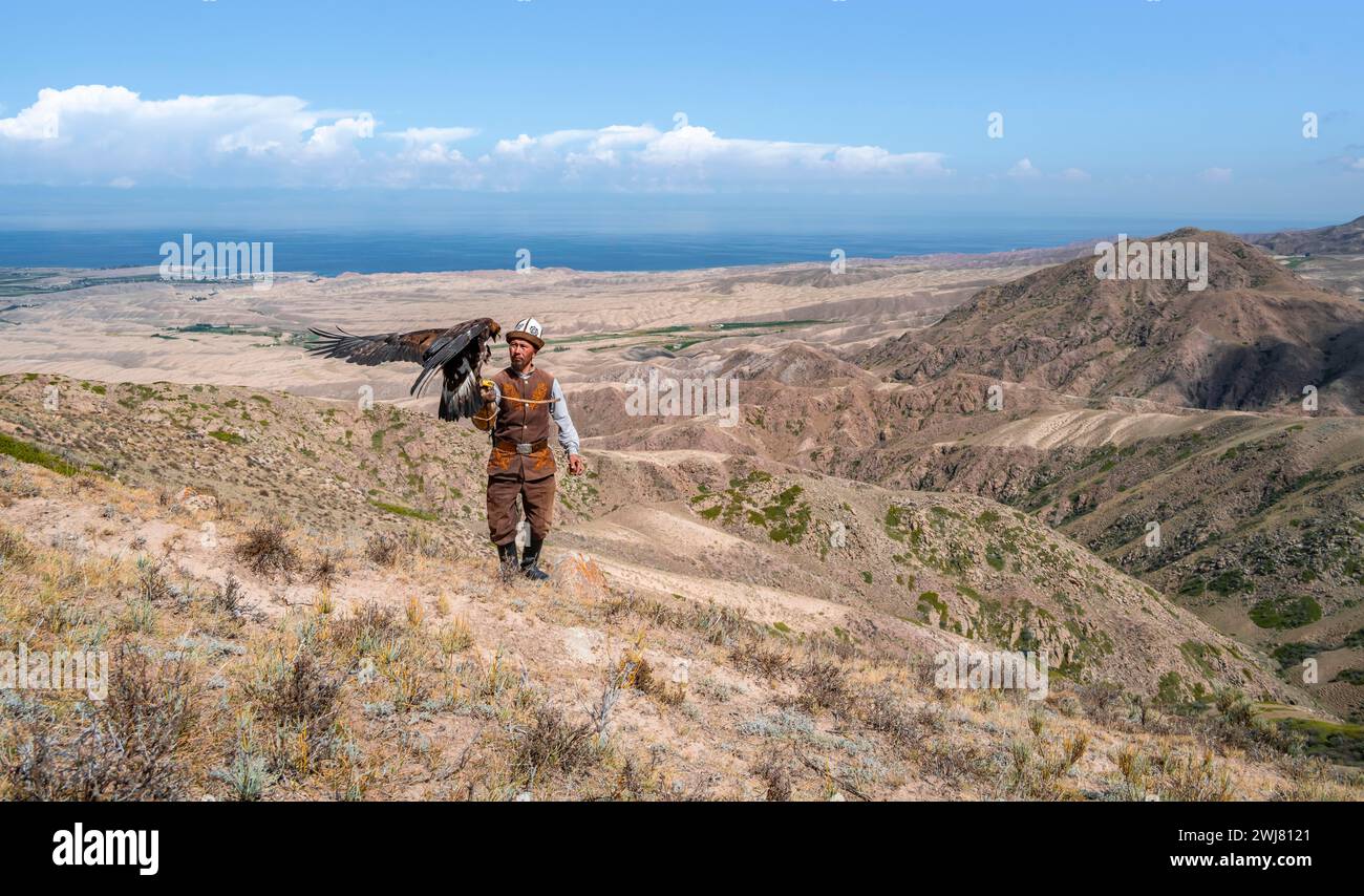 Traditional Kyrgyz eagle hunter hunting in the mountains in a dry ...
