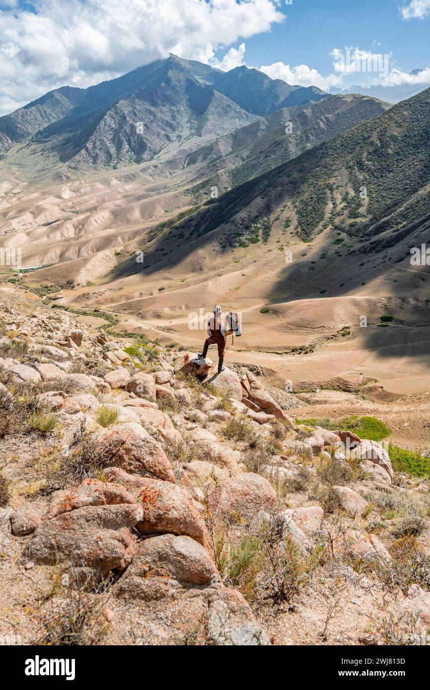 Traditional Kyrgyz eagle hunter hunting in the mountains in a dry ...