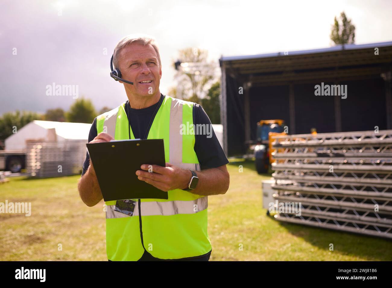 Male Production Worker With Headset Setting Up Outdoor Stage For Music ...